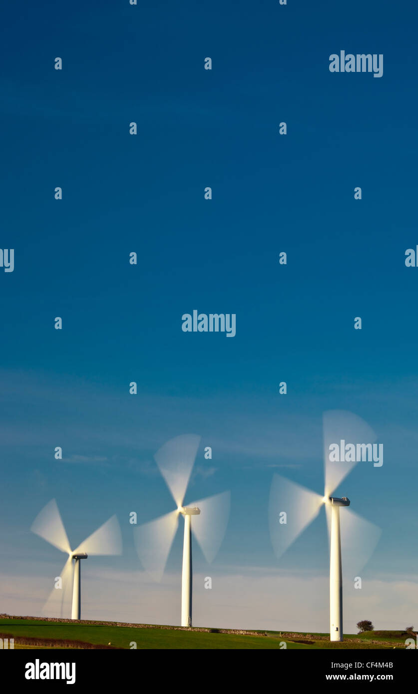 Three wind turbines turning in the wind on top of a hill in the Lake ...