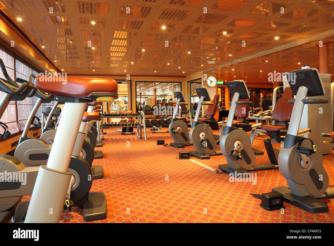 large gym hall with running tracks, exercise bicycle and dumbbells in ...