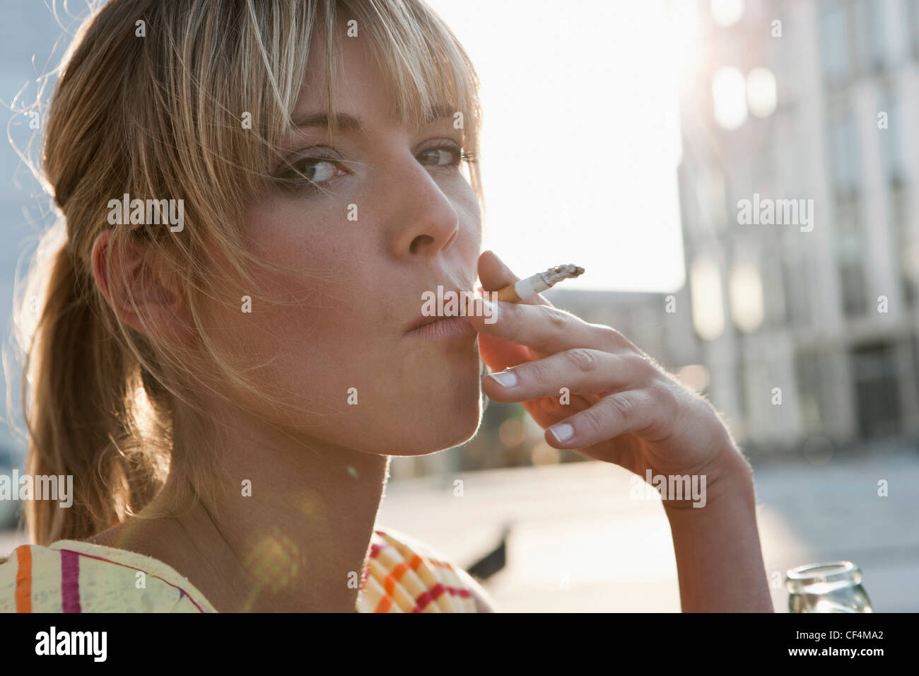 Germany, Cologne, Young woman smoking, portrait Stock Photo - Alamy