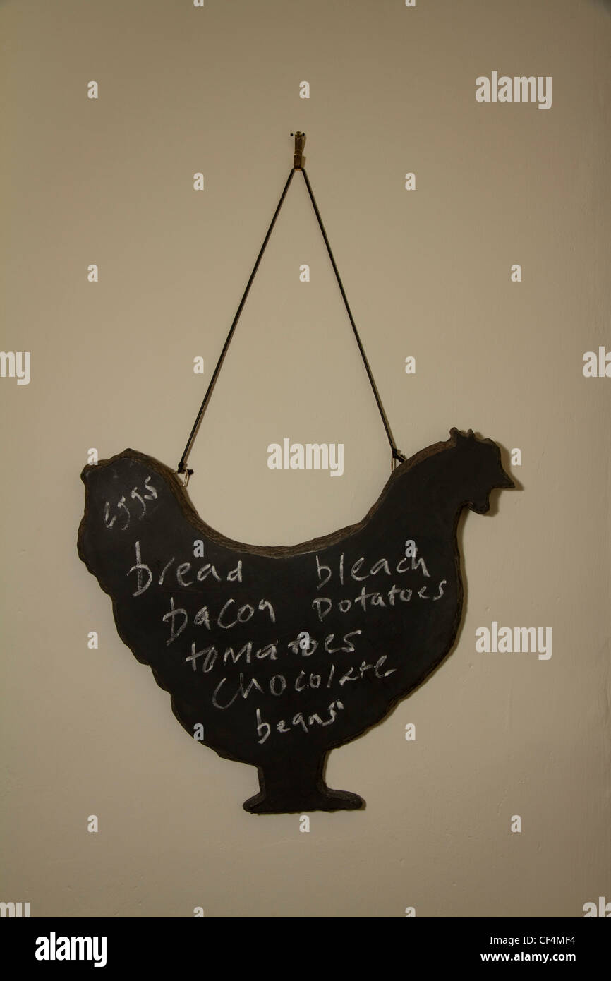 A chicken shaped blackboard hangs on a kitchen wall for reminder ...