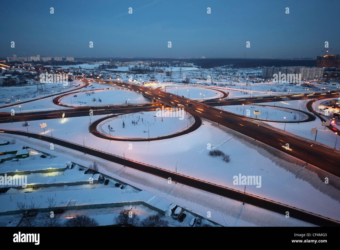 evening winter cityscape with big interchange, lighting columns and ...