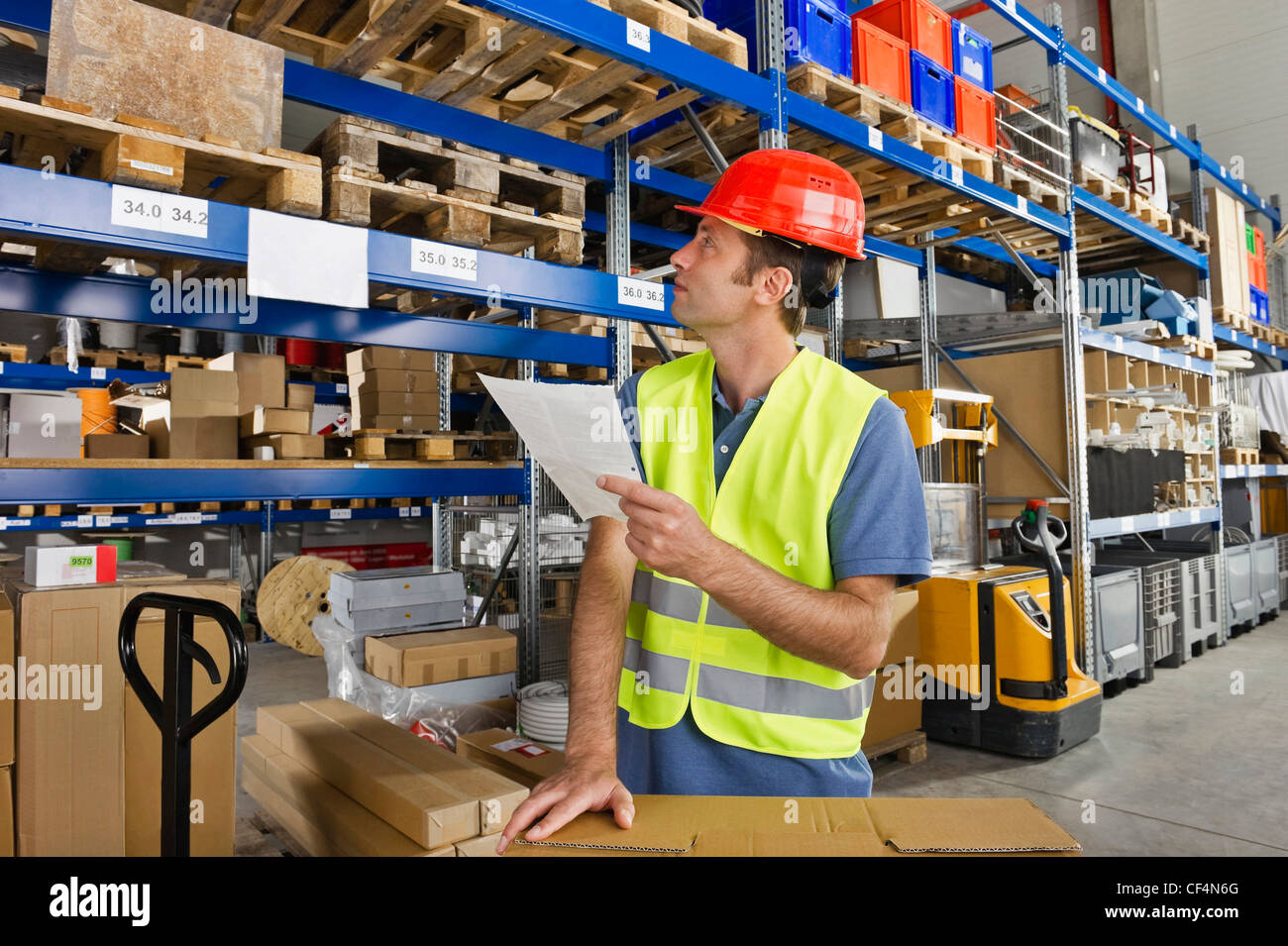 Germany, Bavaria, Munich, Manual worker with clipboard in warehouse ...