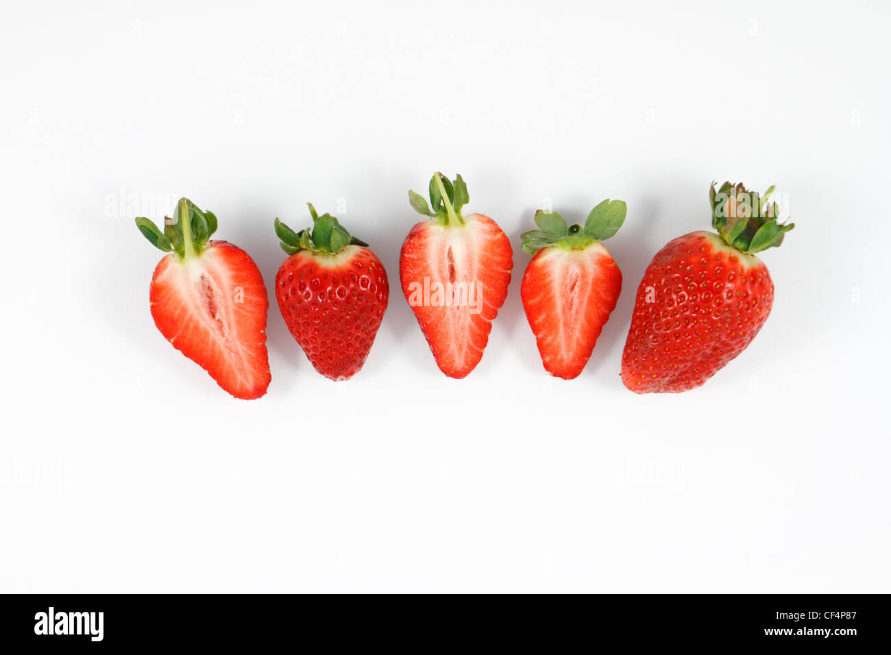Whole and halved strawberries on a white background Stock Photo - Alamy