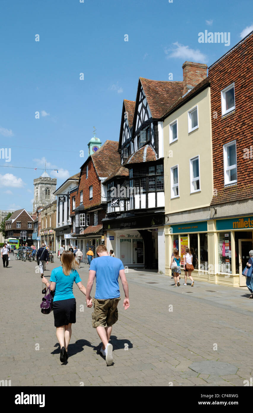 A young couple walking hand in hand along the pedestrianised high ...
