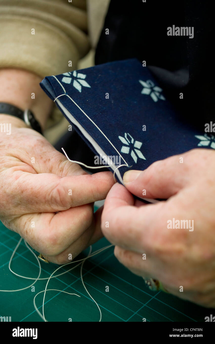Sewing together the cover of a hand made book Stock Photo - Alamy