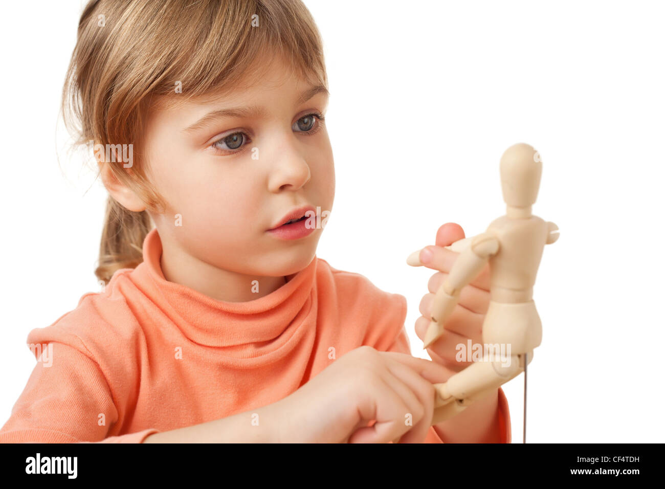 pretty little girl is played by wooden little manikin isolated on white ...