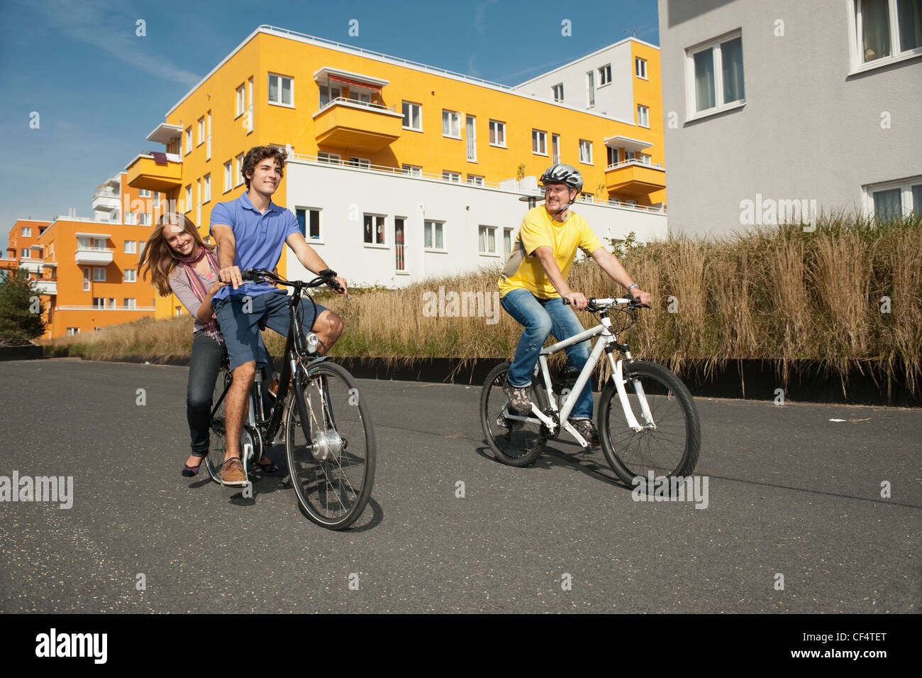 Germany, Bavaria, Man riding bicycle and girl sitting back, smiling ...