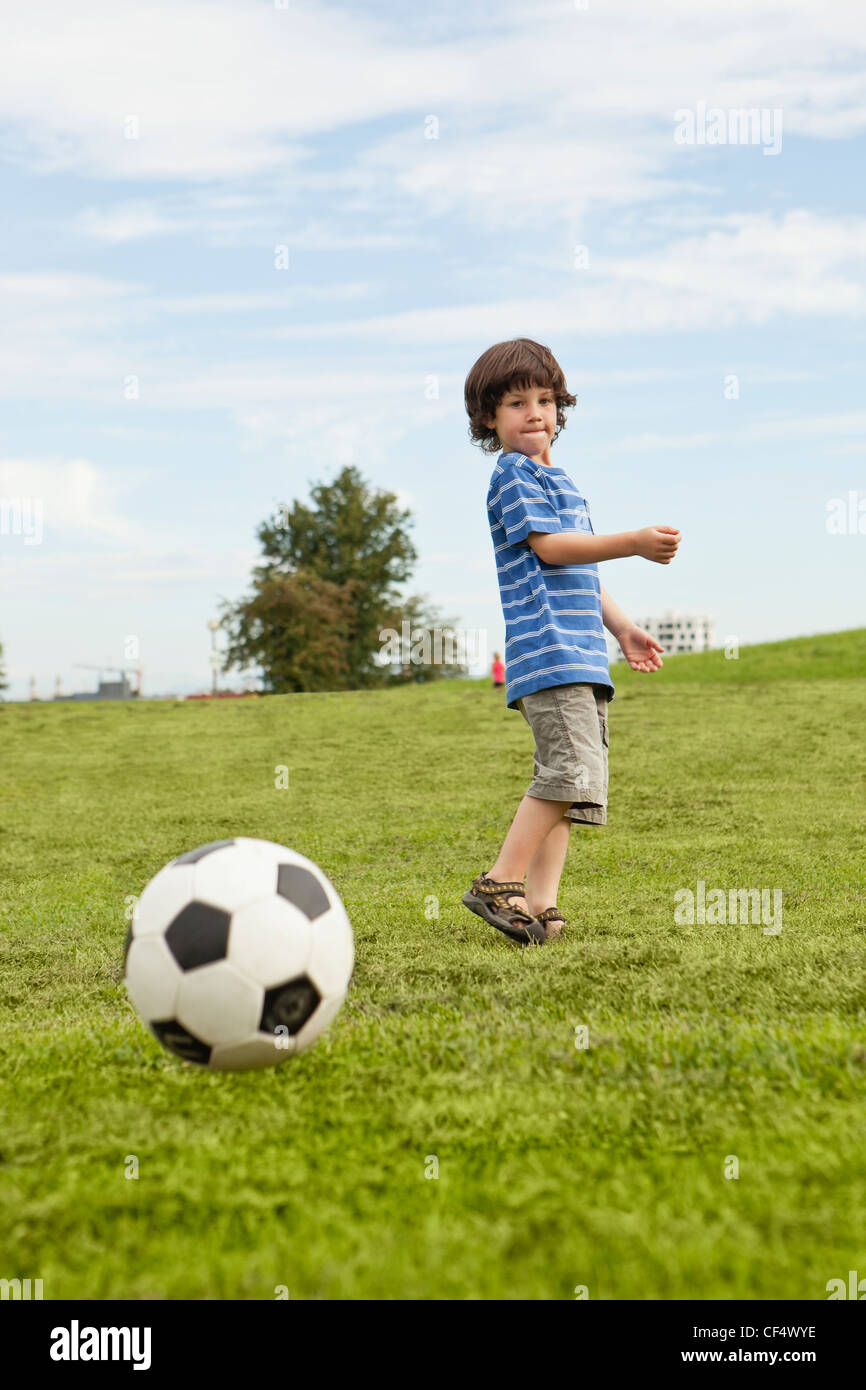 Germany, Bavaria, Boy playing with soccer ball in park Stock Photo - Alamy