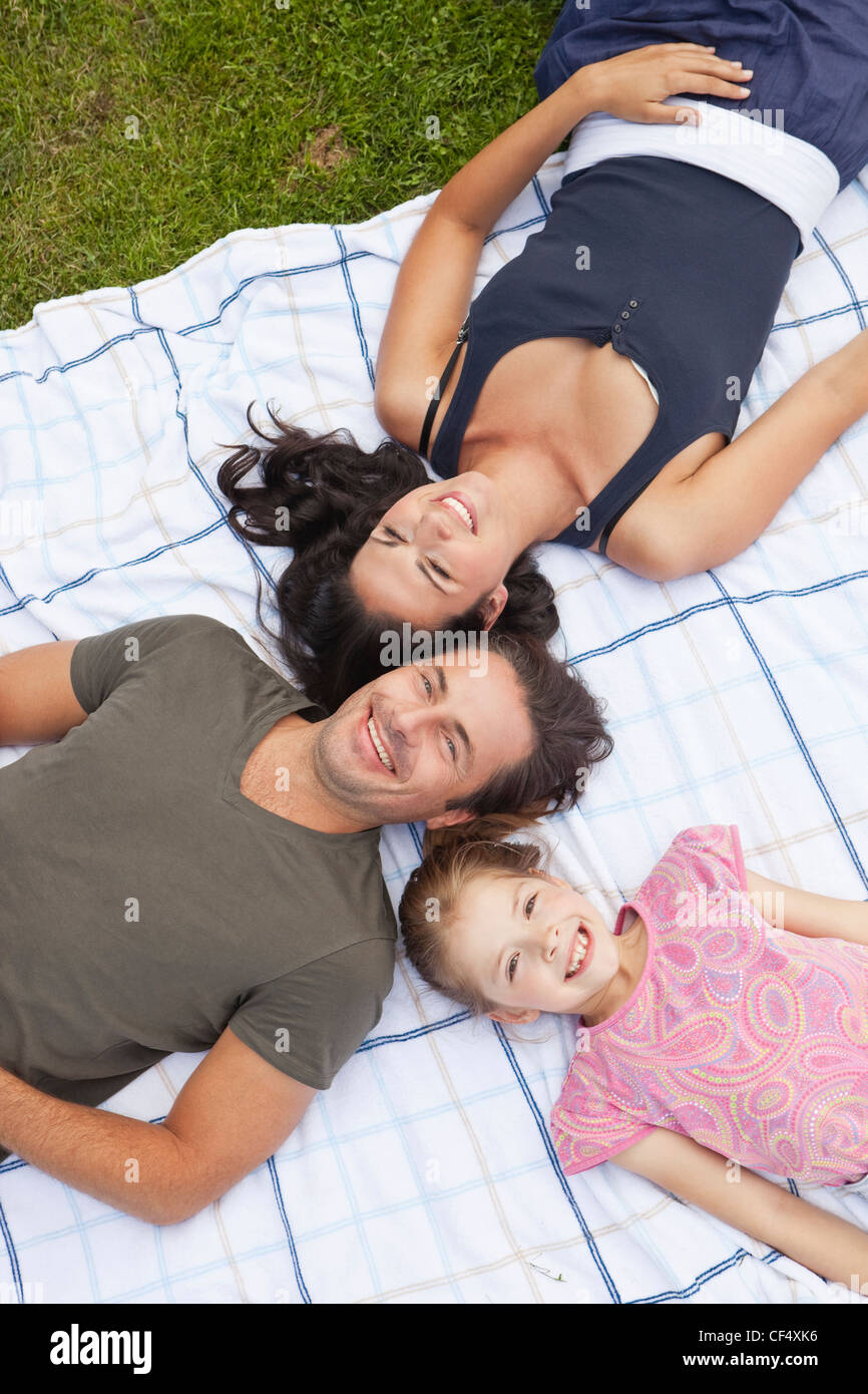Germany, Bavaria, Family lying on blanket in park, smiling Stock Photo ...