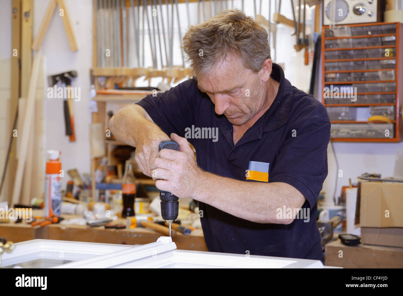 Germany, Upper Bavaria, Schaeftlarn, Carpenter using drill machine ...