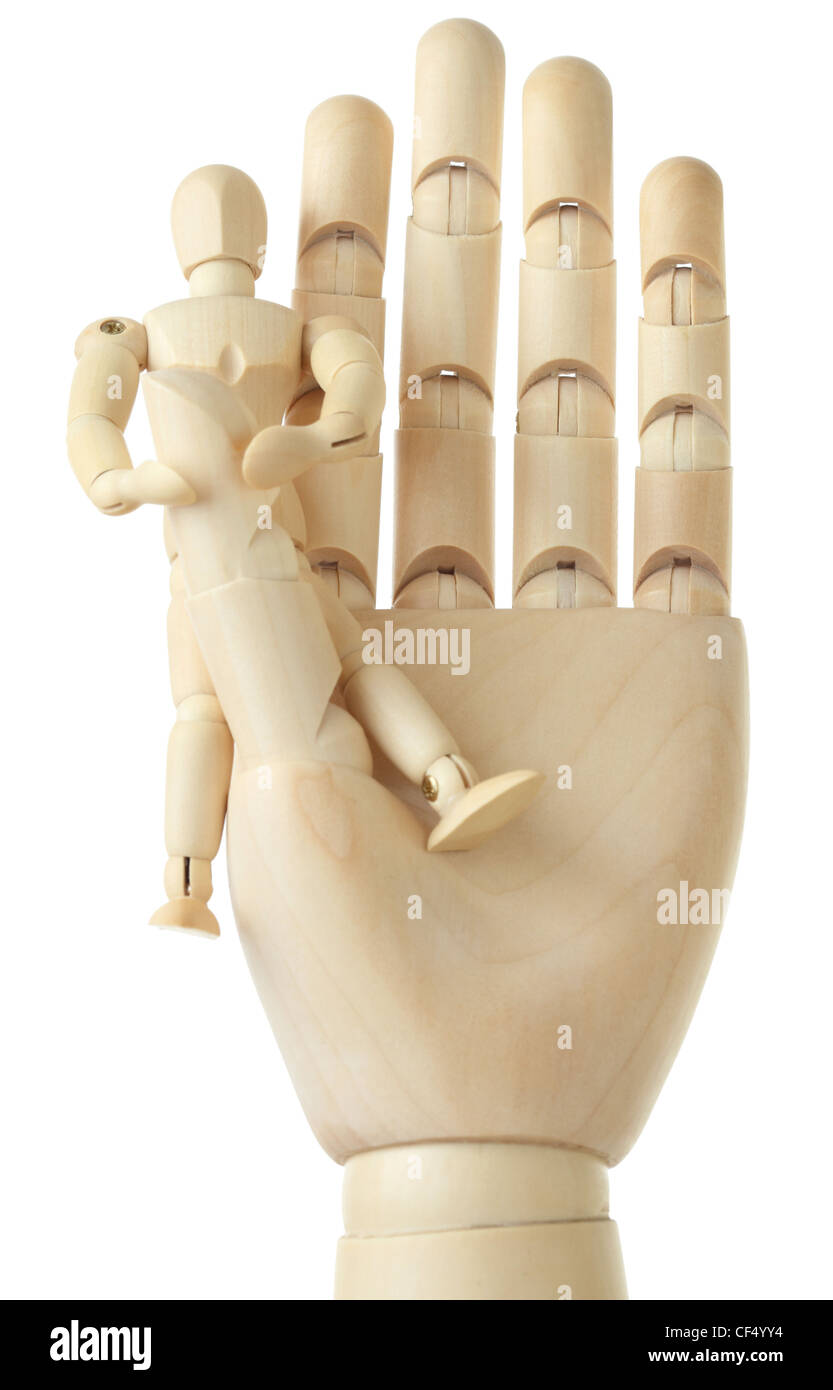 wooden figure of little man sitting on big hand, front view, isolated ...