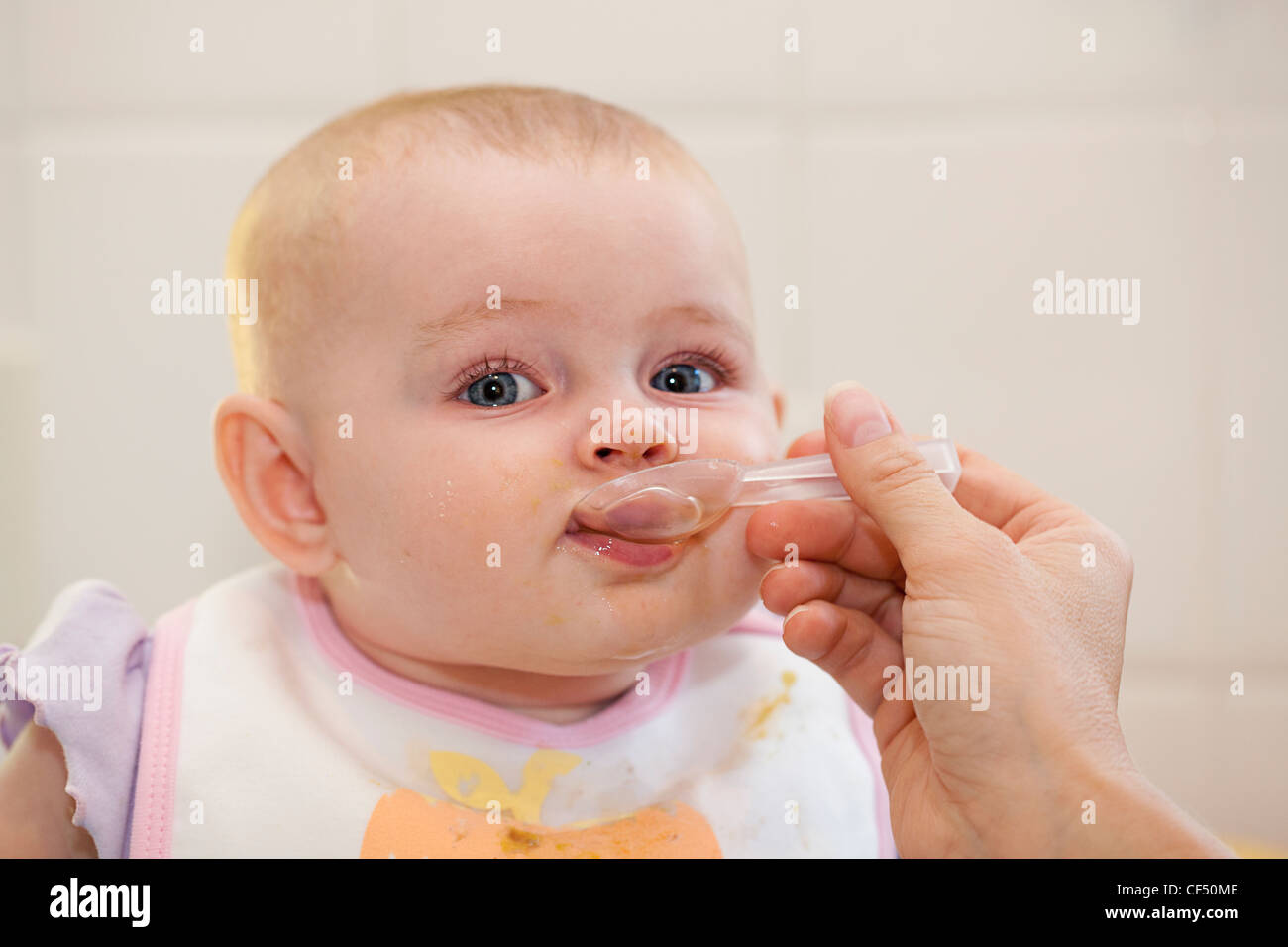 Baby spoon feeding Stock Photo - Alamy