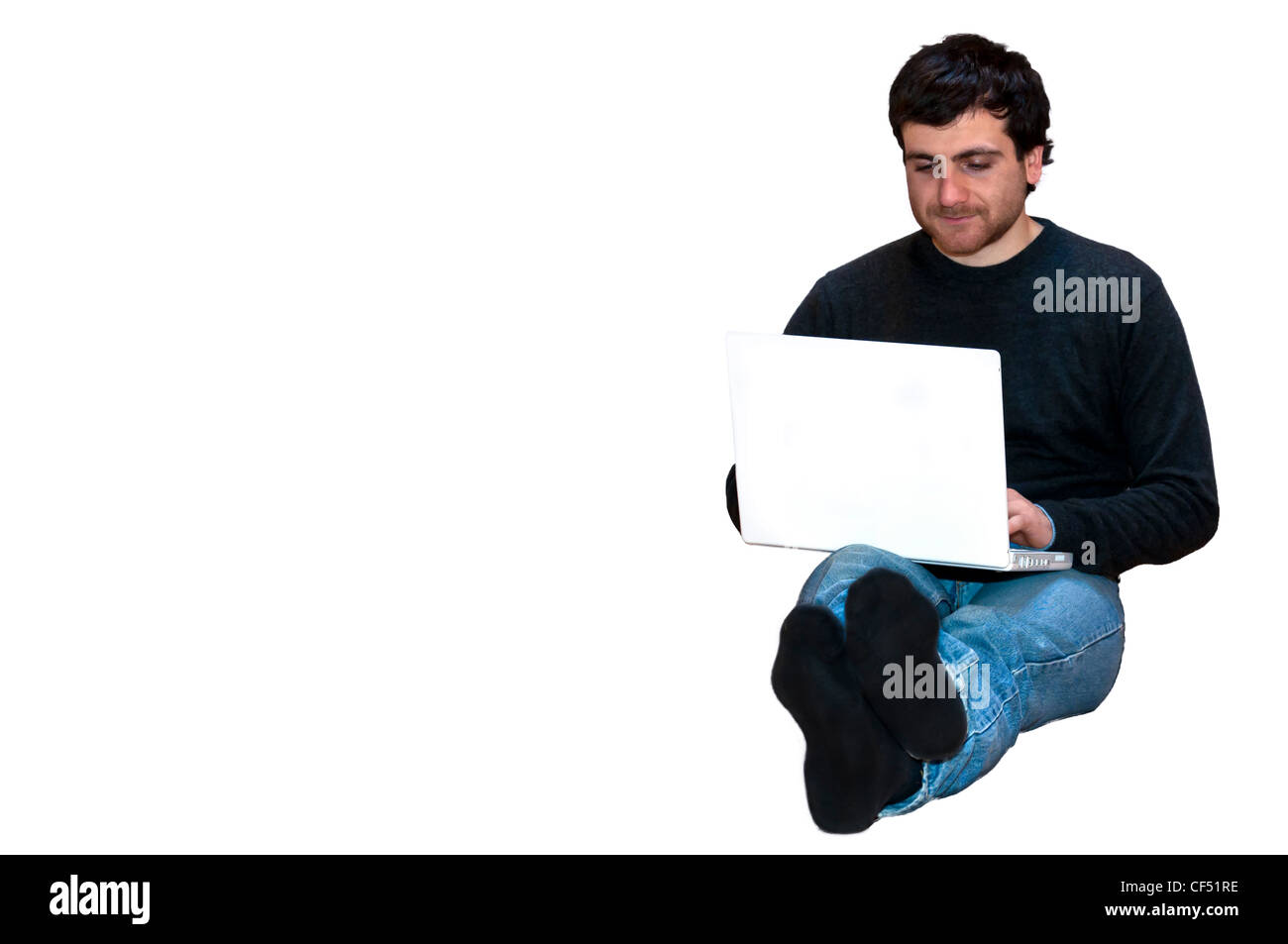 young man sitting on the floor cross-legged with laptop Stock Photo - Alamy