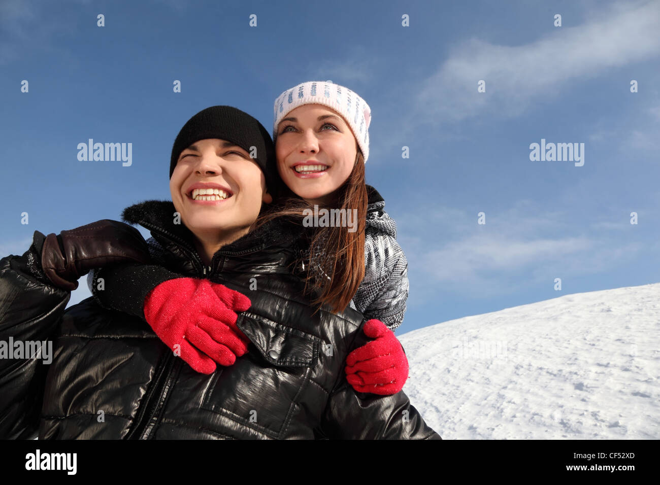 young girl embracing man from back, smiling and looking left, winter ...