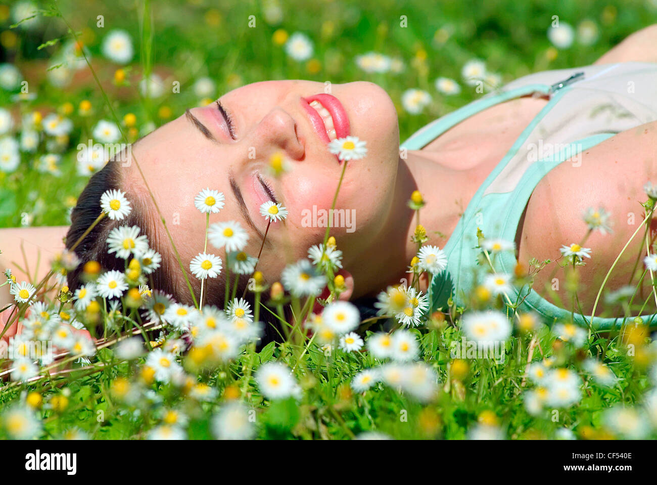 Brunette Female Lying In The Grass Amongst Daisies Head Back And