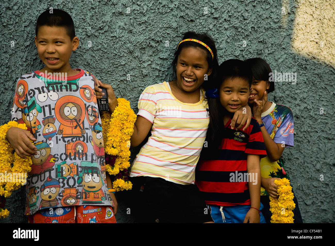 Thai children with mobile phone and floral garlands to celebrate the ...