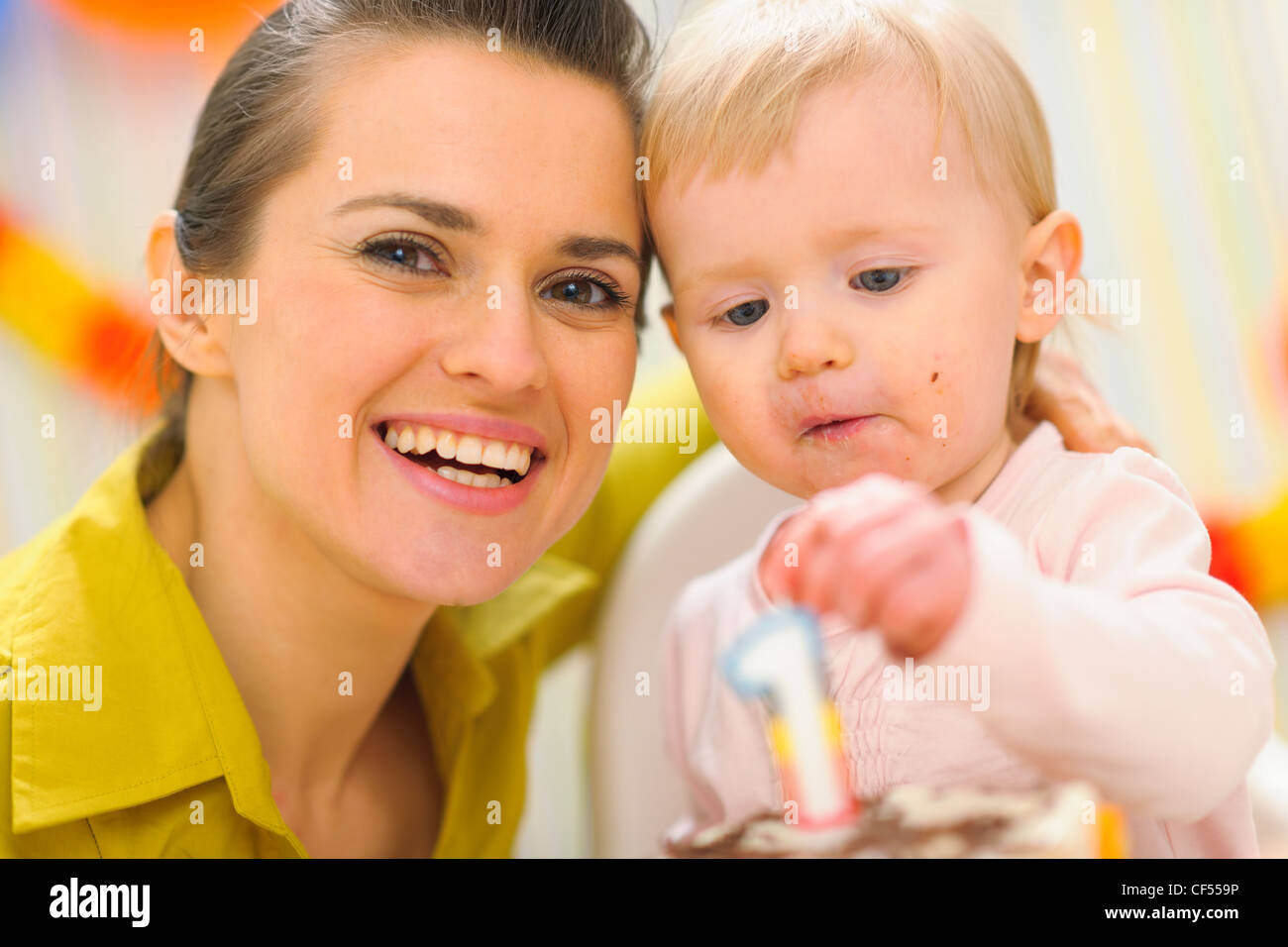 Portrait of mom and baby eating birthday cake Stock Photo - Alamy