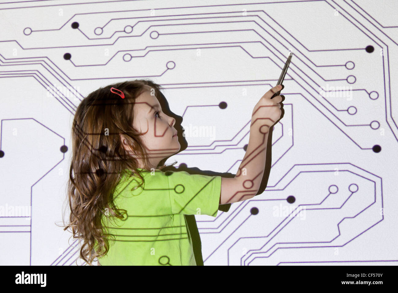 pretty little girl shows pointer on electric scheme throw projector on ...