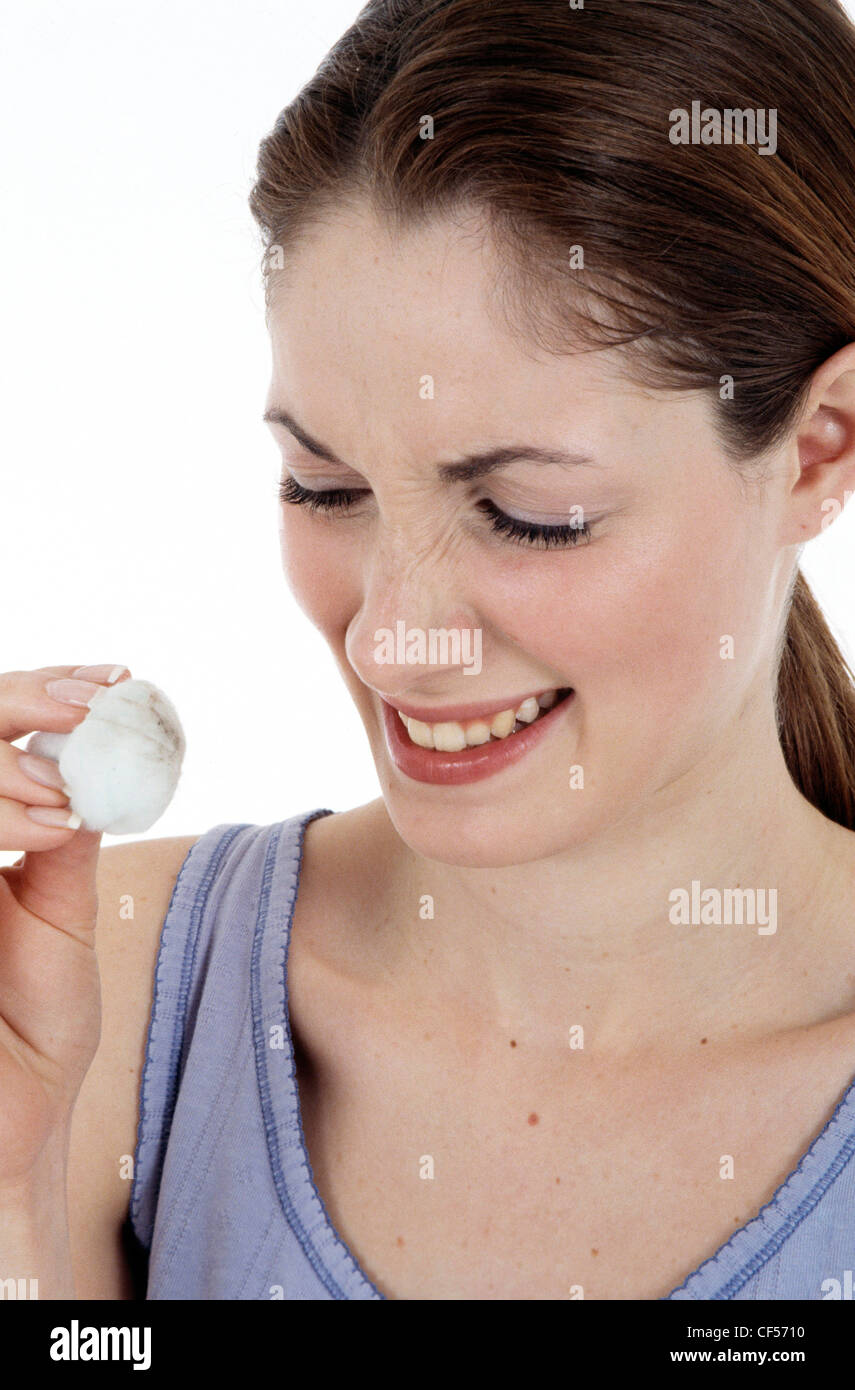 Female holding dirty cotton wool ball frowning Stock Photo - Alamy