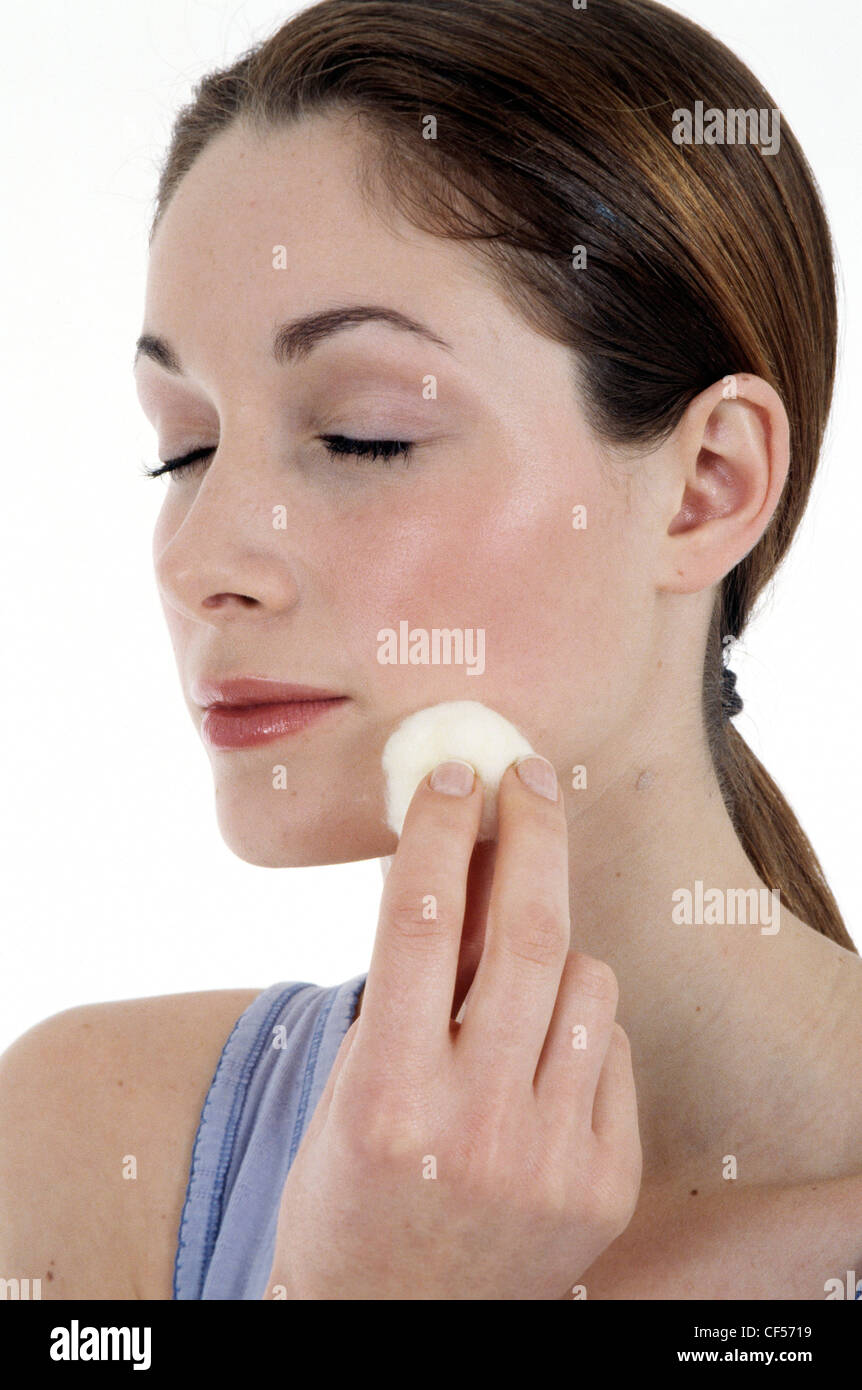 Female wiping cheek with cotton wool ball Stock Photo - Alamy