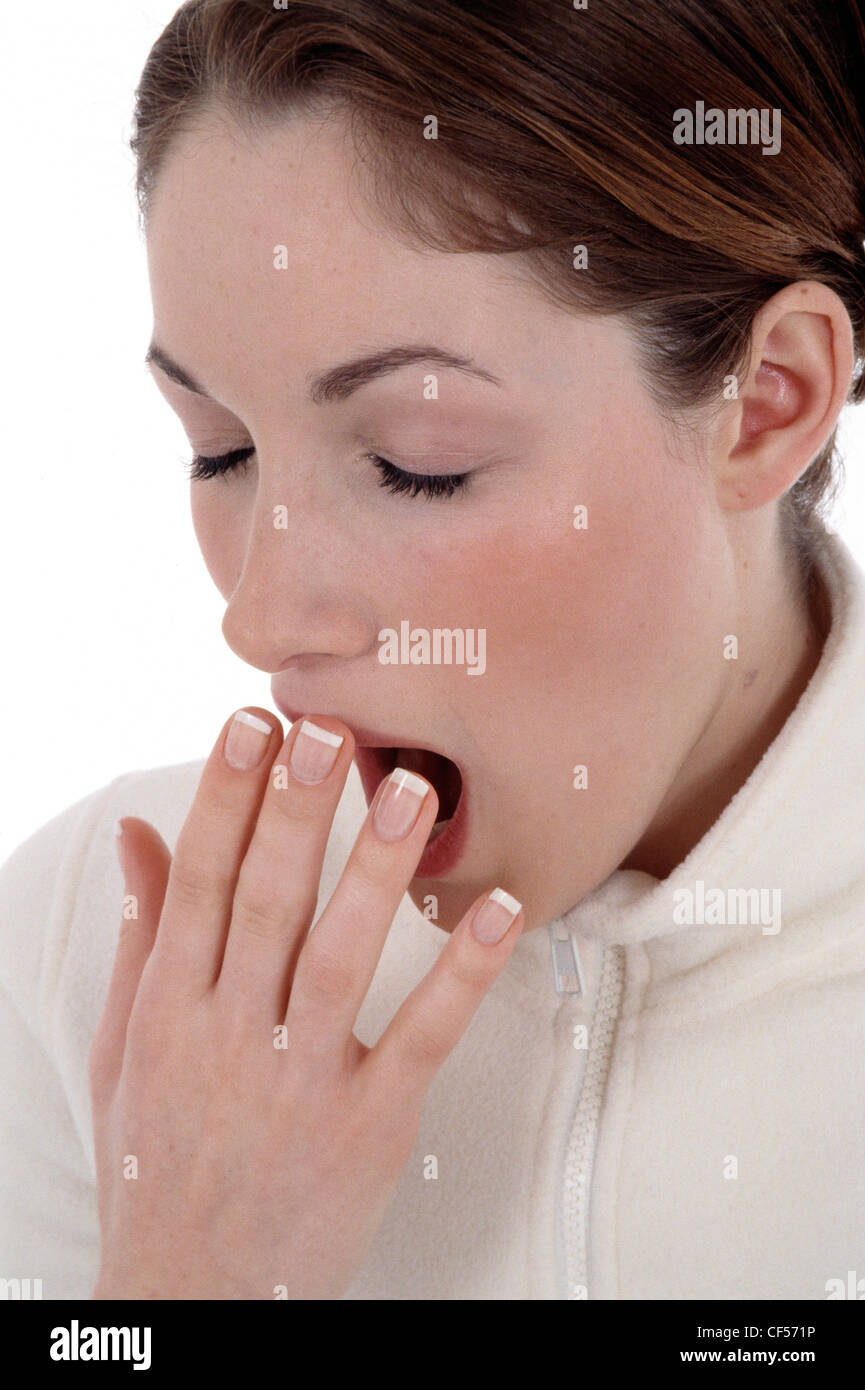 Female yawning with hand in front of mouth Stock Photo - Alamy