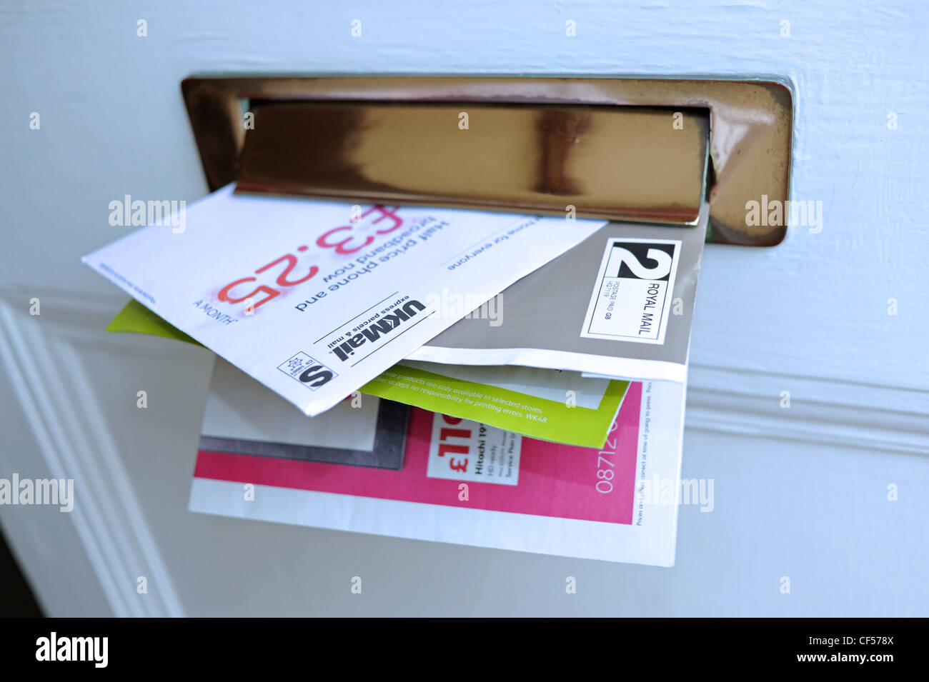 Junk mail in a private home letter box being posted through front door ...
