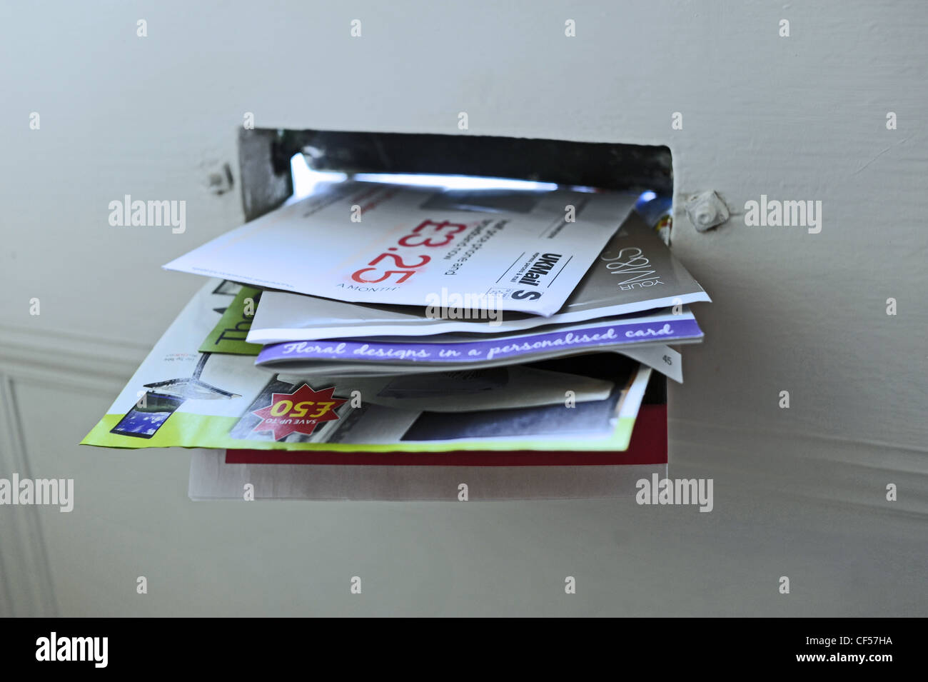 Junk mail in a private home letter box being posted through front door ...