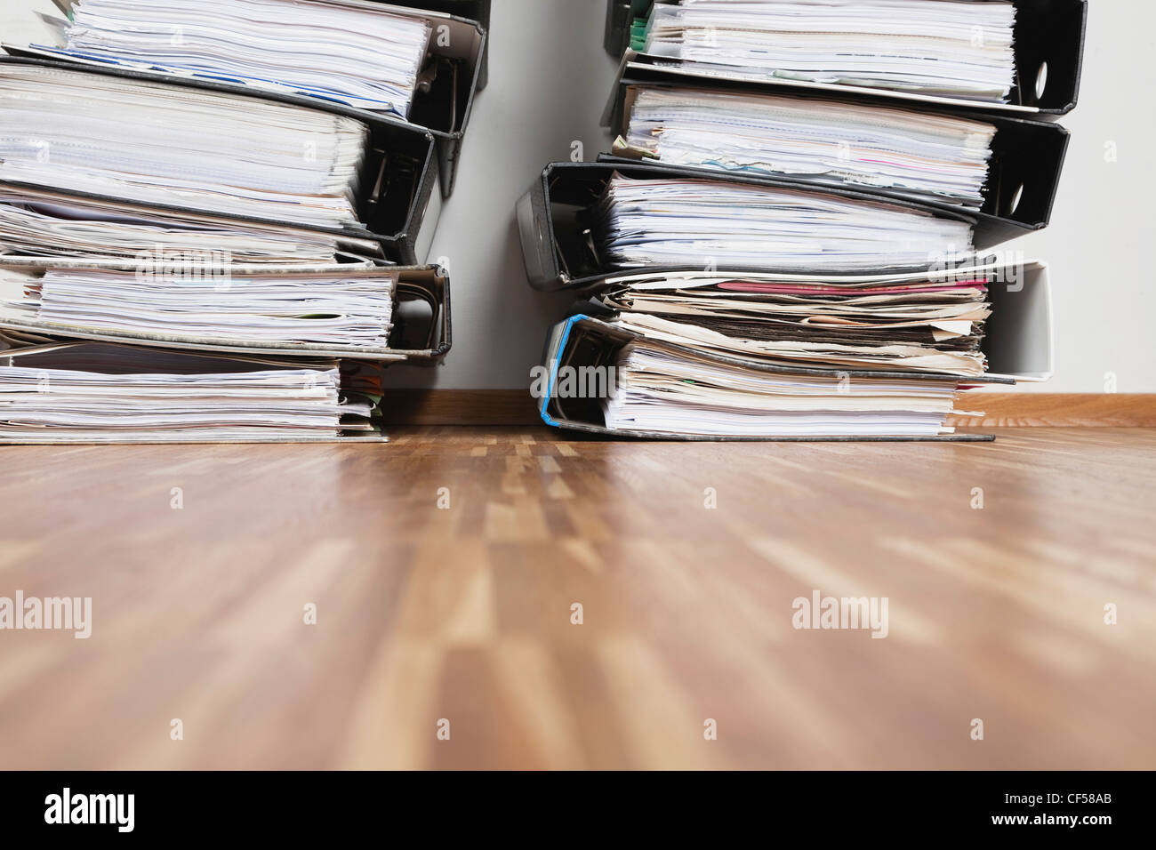 Piled of office files on parquet floor Stock Photo - Alamy