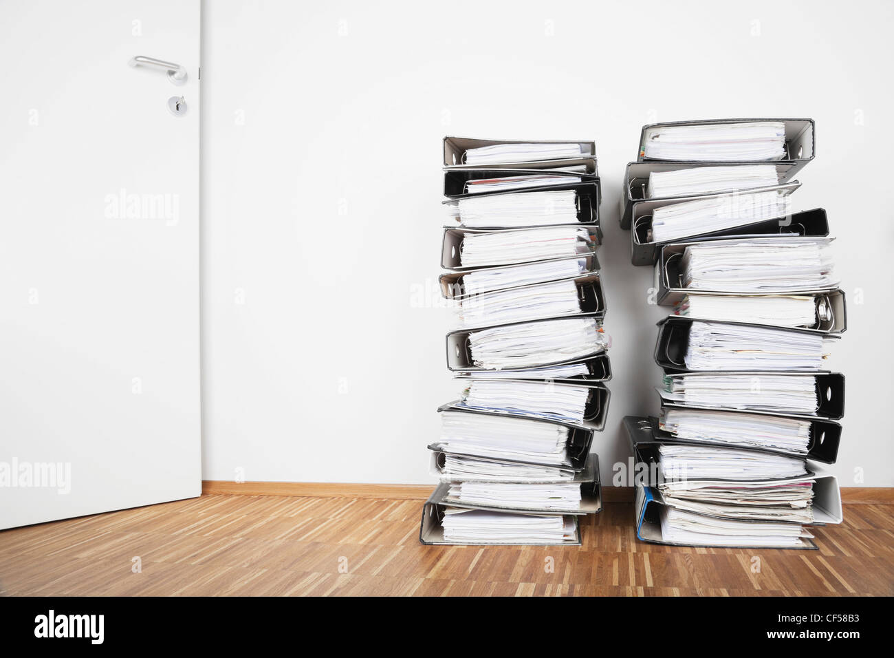 Piled of office files on parquet floor Stock Photo - Alamy