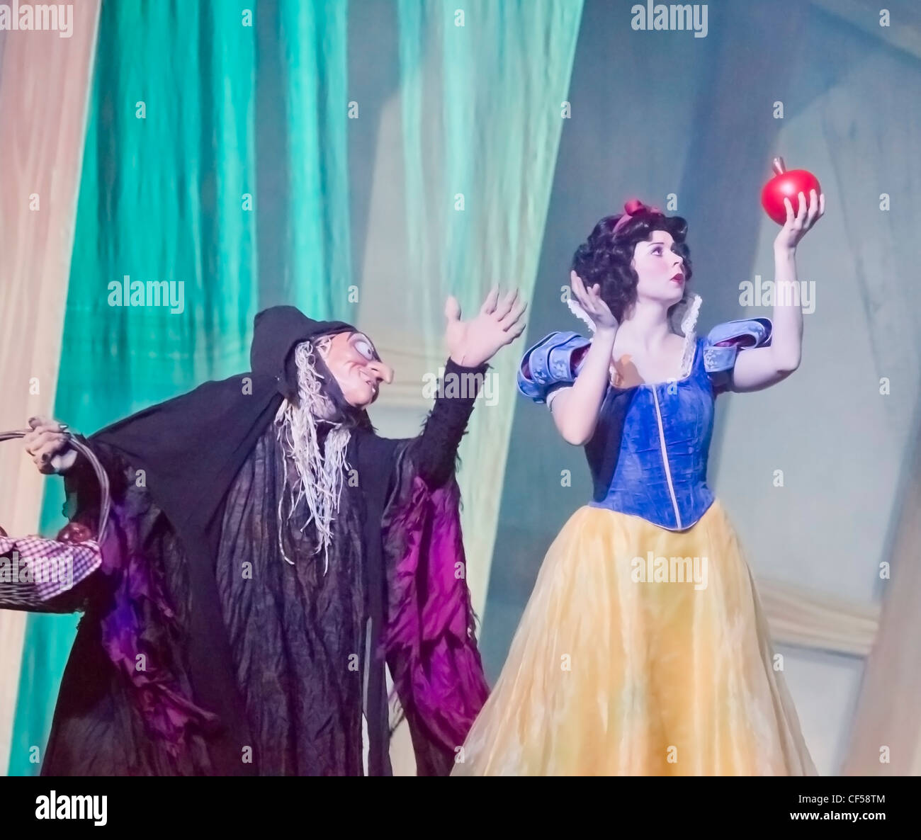 Snow White looks at the apple while the Evil Witch watches at the ...