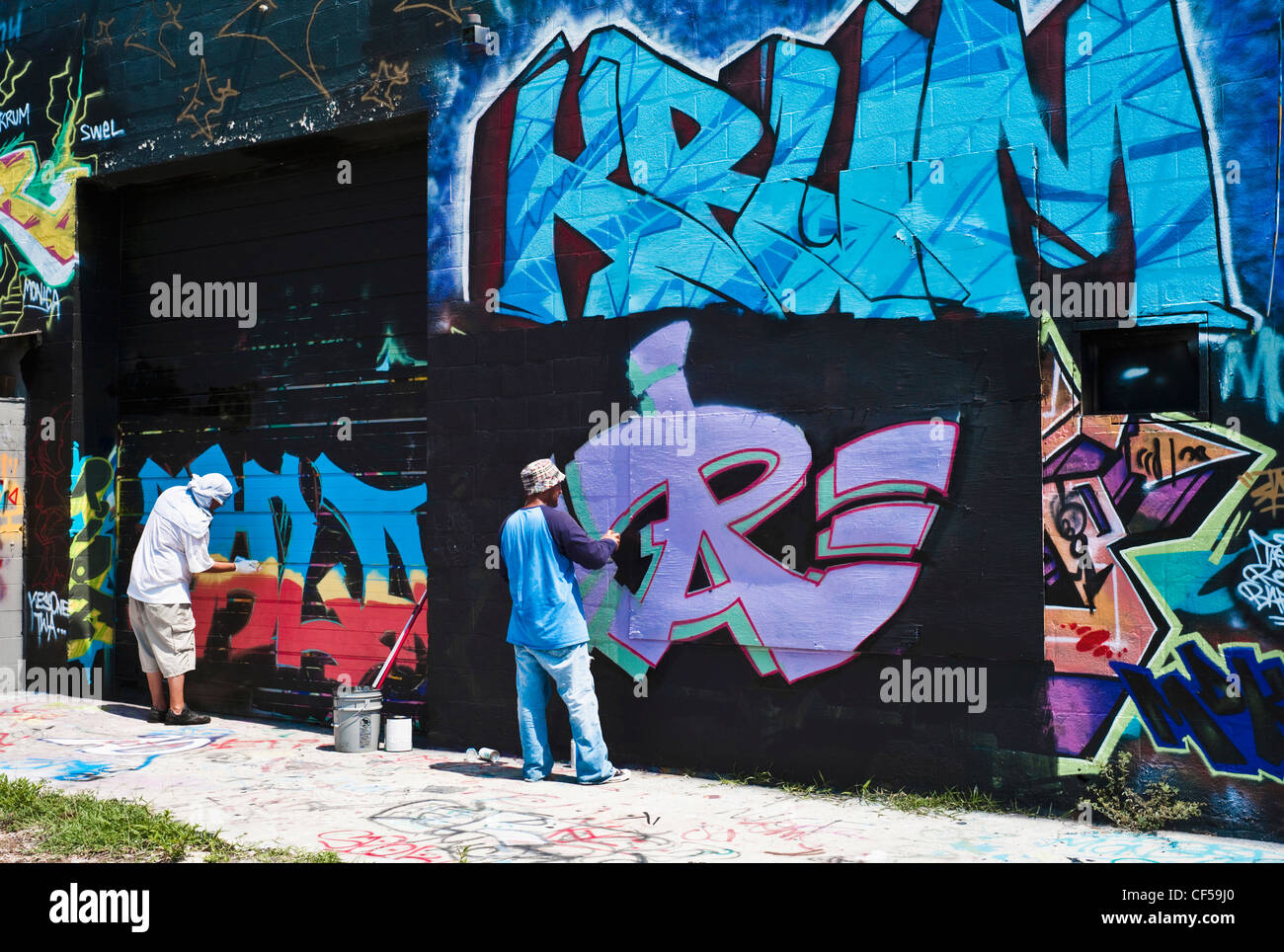 USA, Florida, Orlando, Male graffiti artists painting wall Stock Photo ...