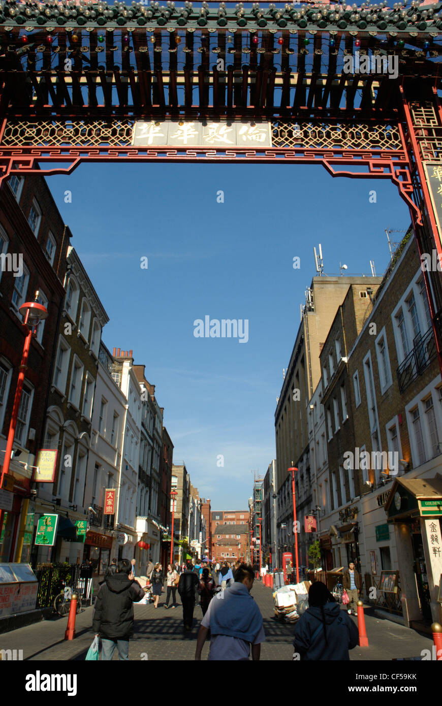 Passers by under the gate at the end of Gerrard Street in Chinatown ...