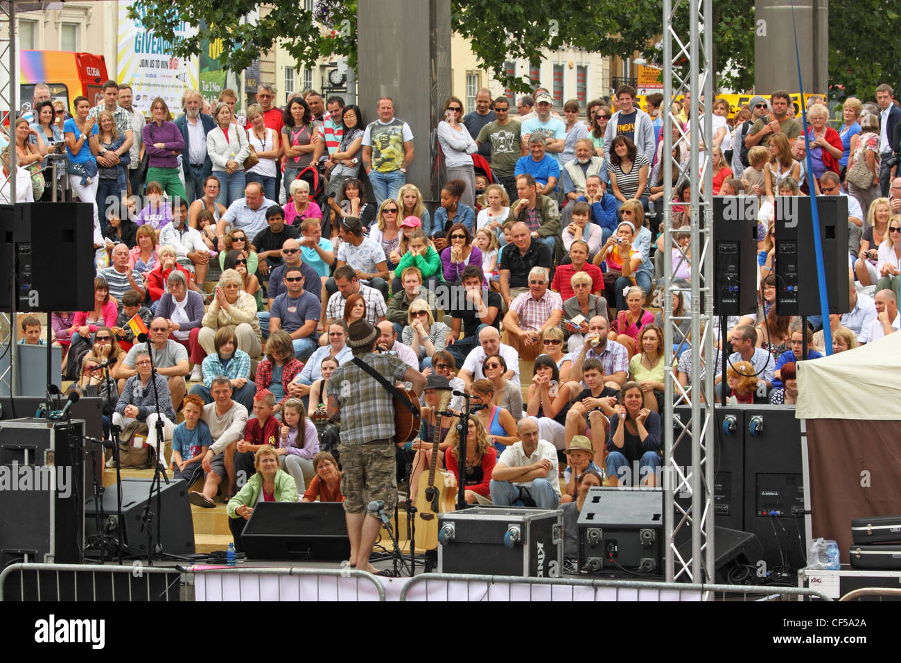 An unknown musician entertaining a colorful audience at a summer ...