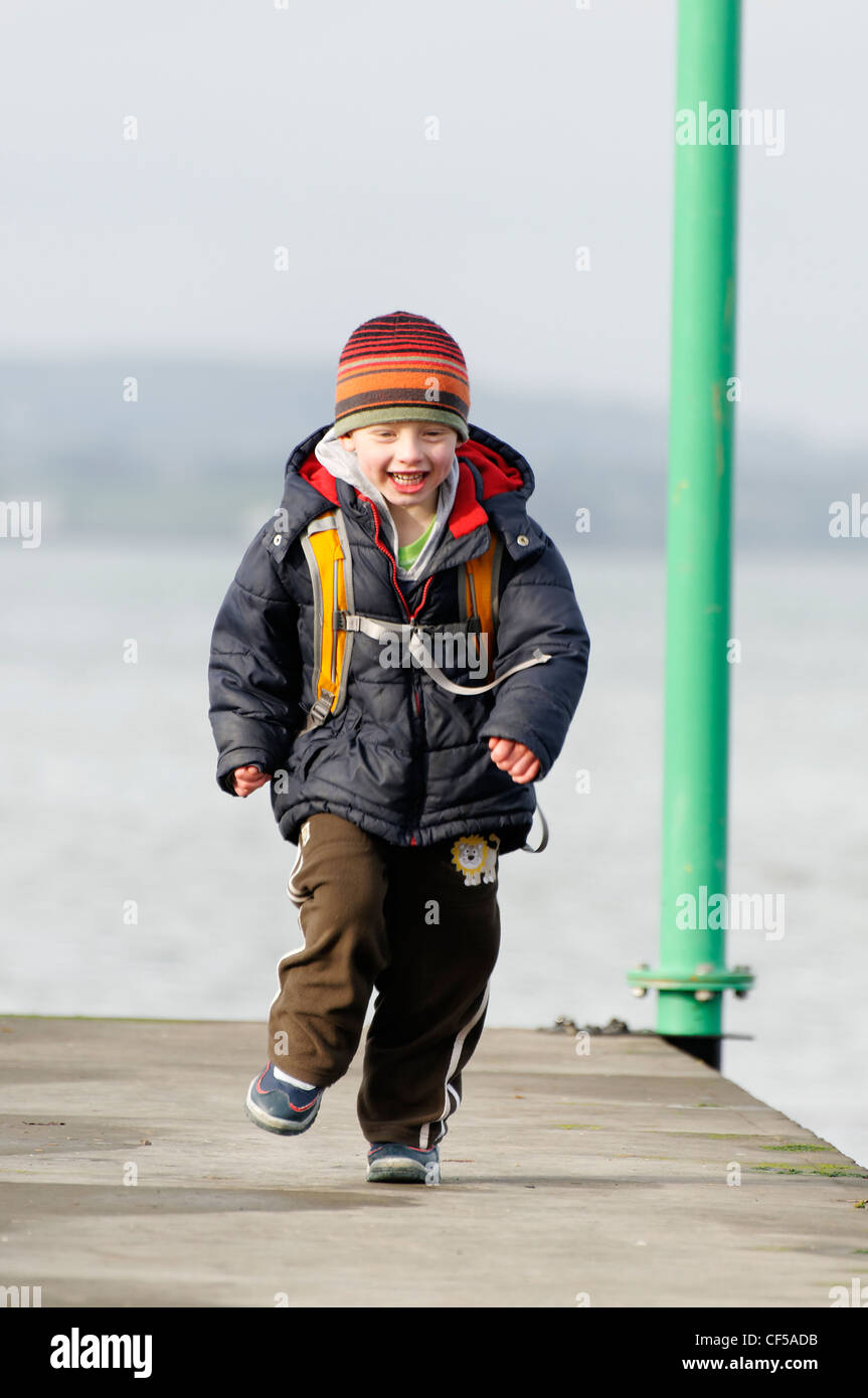 A boy running on a small jetty Stock Photo - Alamy