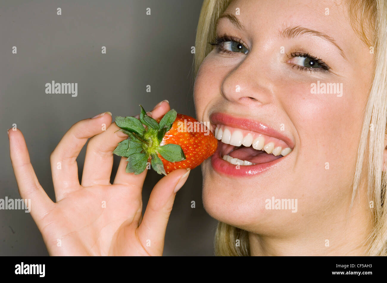 Female eating a strawberry Stock Photo - Alamy