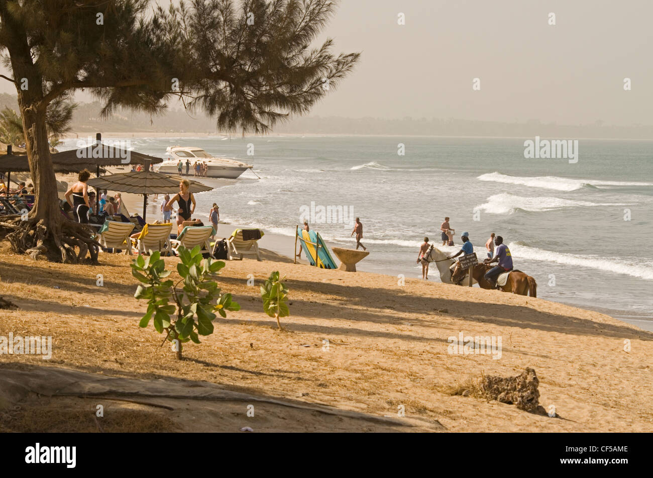locals mingle with holiday makers on the beach at Kotu point Gambia ...