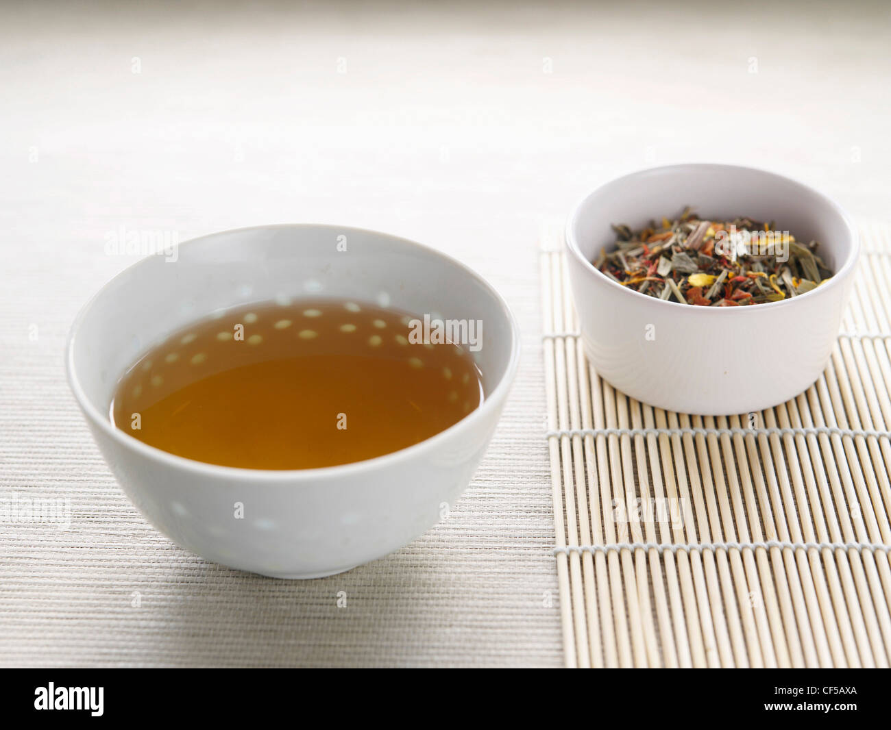 Tea cup with dried tea in bowl on straw mat Stock Photo - Alamy