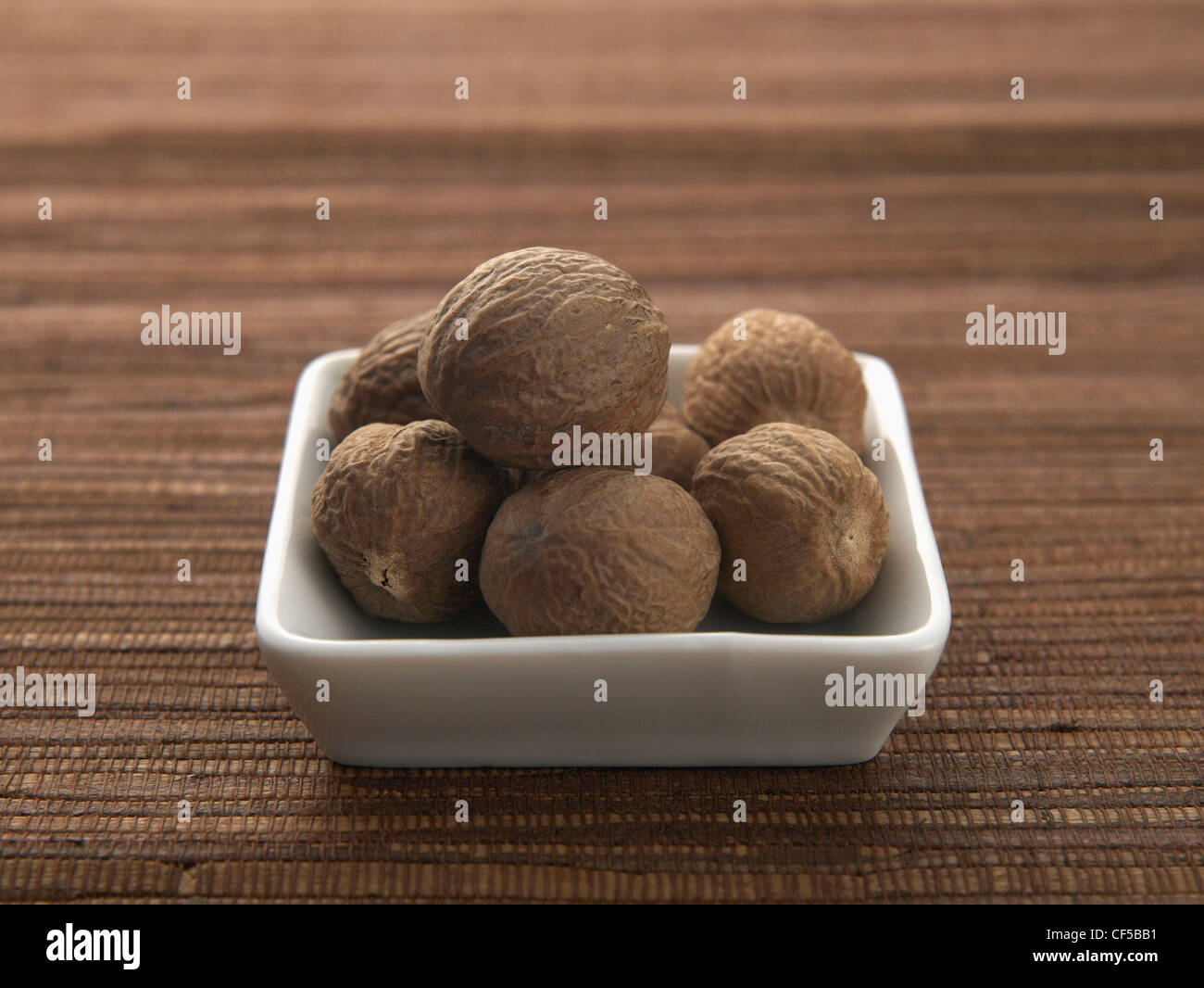 Nutmeg in bowl, close up Stock Photo - Alamy