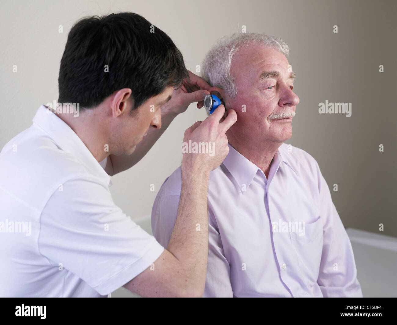 Germany, Hamburg, Doctor examining patient with Otoscope Stock Photo ...