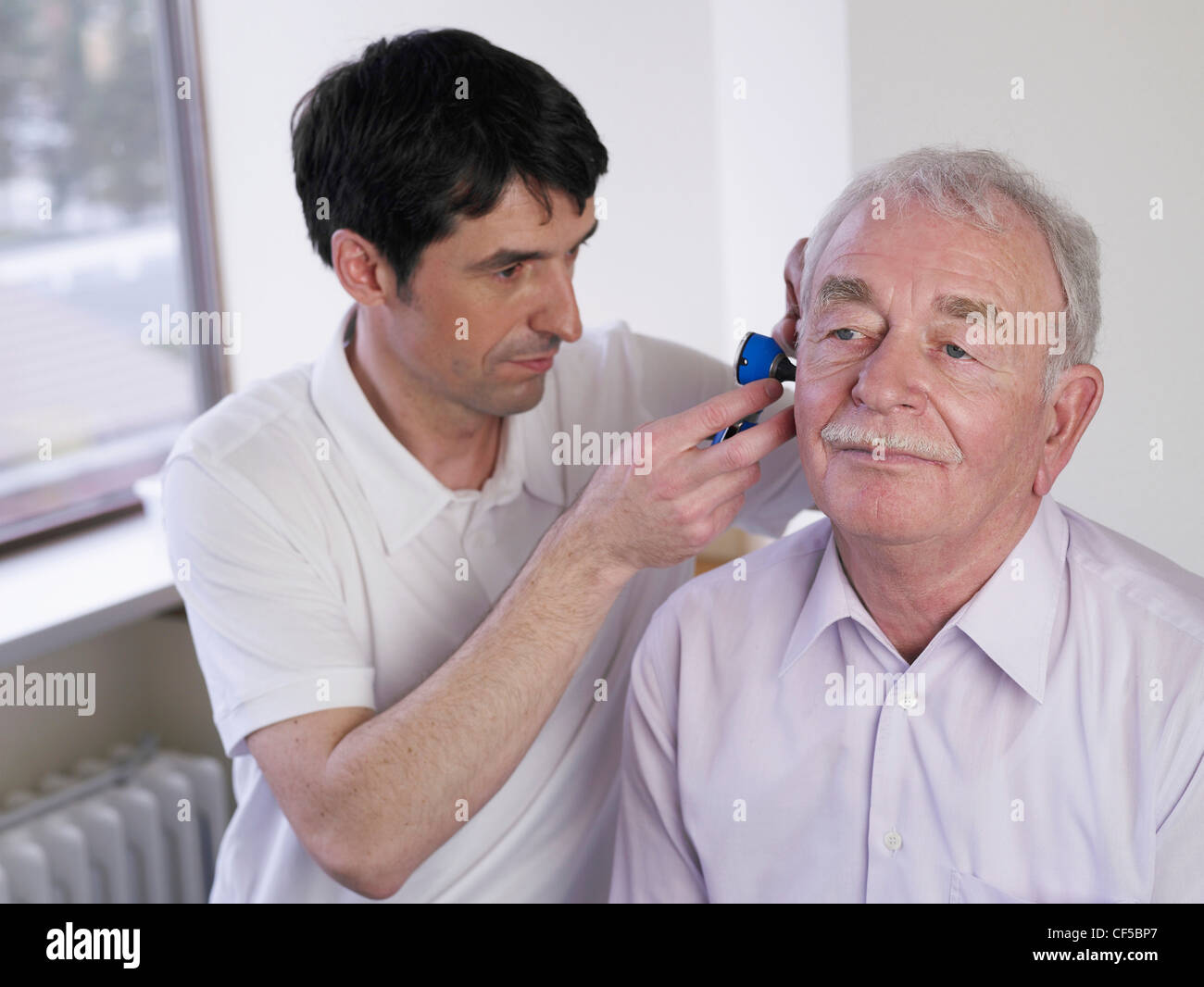 Germany, Hamburg, Doctor examining patient with Otoscope Stock Photo ...