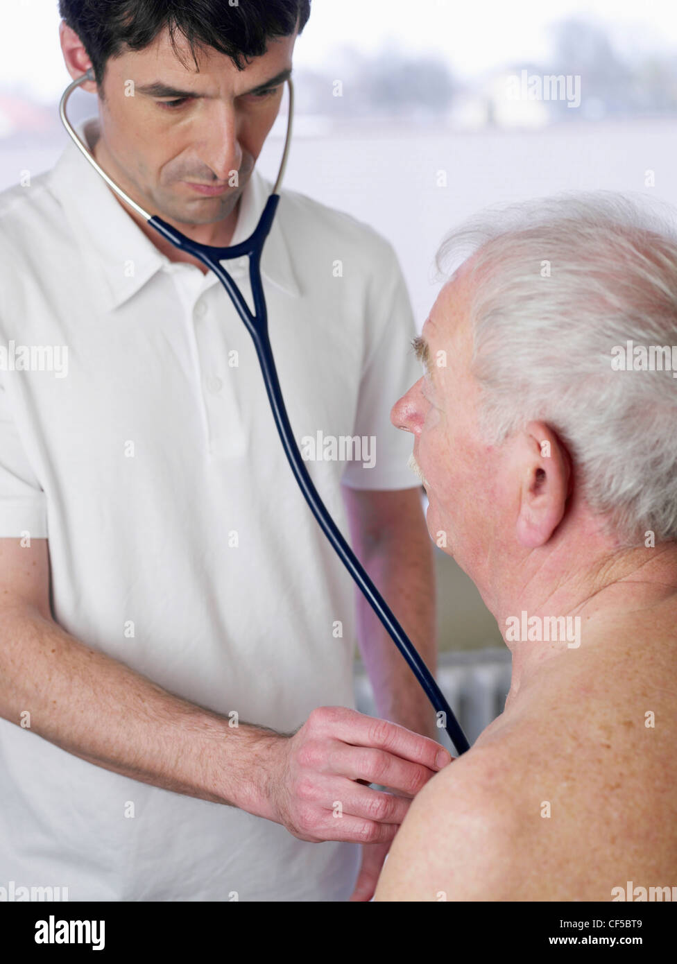 Germany, Hamburg, Doctor examining patient with stethoscope in clinic ...