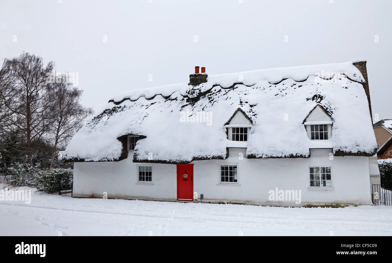 Thatched cottage with red door in winter snow Milton Stock Photo - Alamy