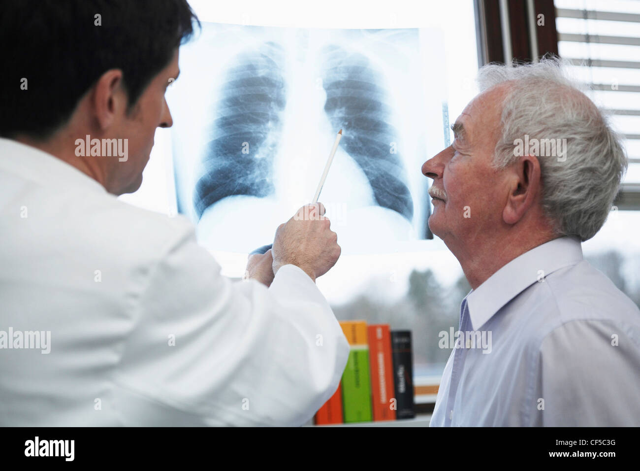 Germany, Hamburg, Doctor and patient with x-ray report in clinic Stock ...