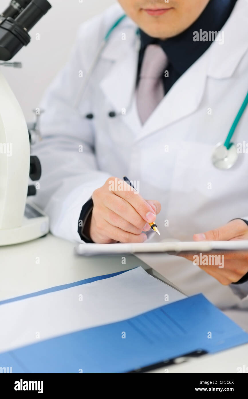 Closeup on male researcher making notes in clipboard Stock Photo - Alamy