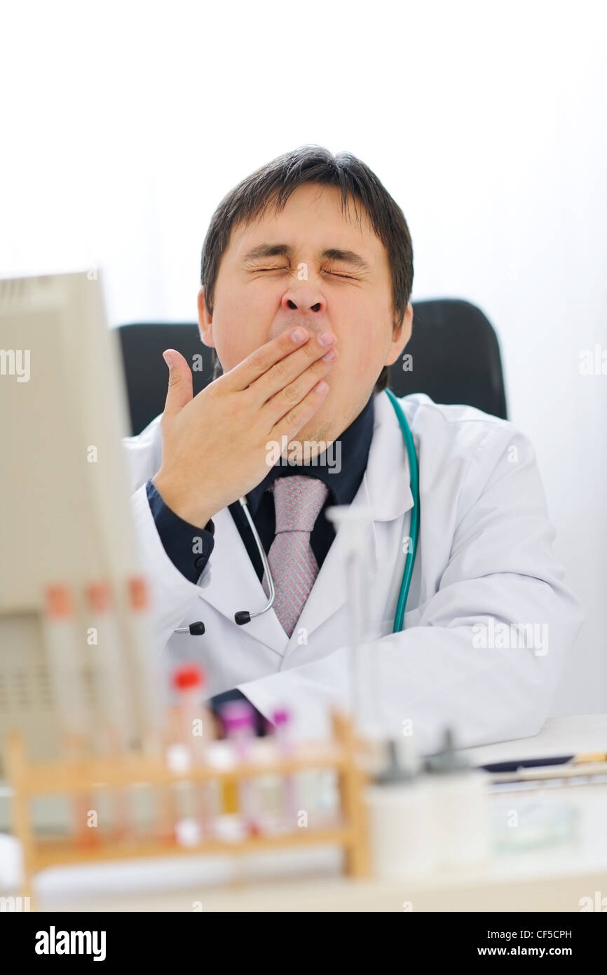 Tired medical doctor yawing Stock Photo - Alamy