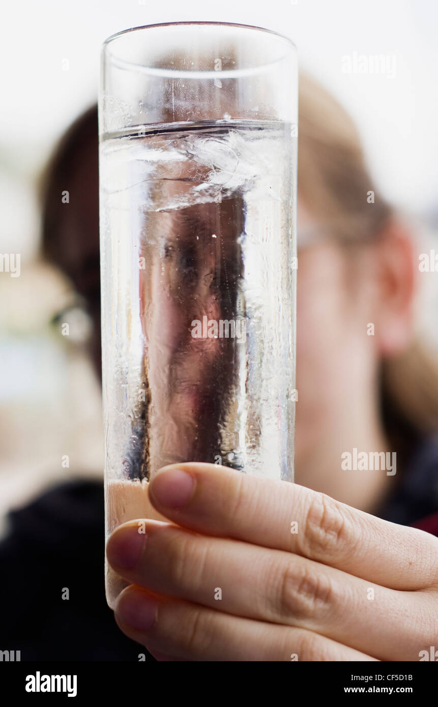 Greece, Ionian Islands, Ithaca, Woman face reflecting in glass of water ...