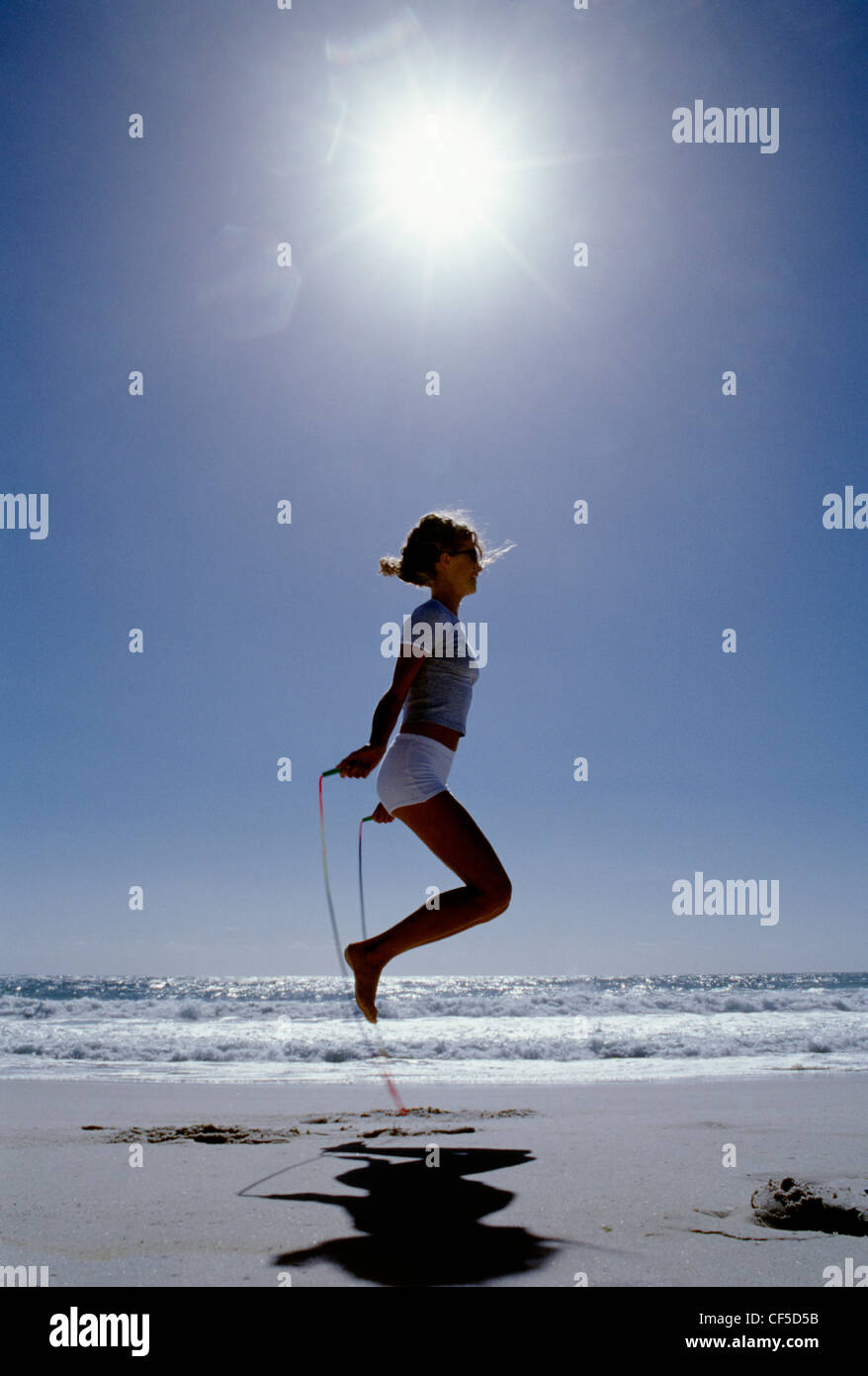 Female skipping on beach Stock Photo - Alamy