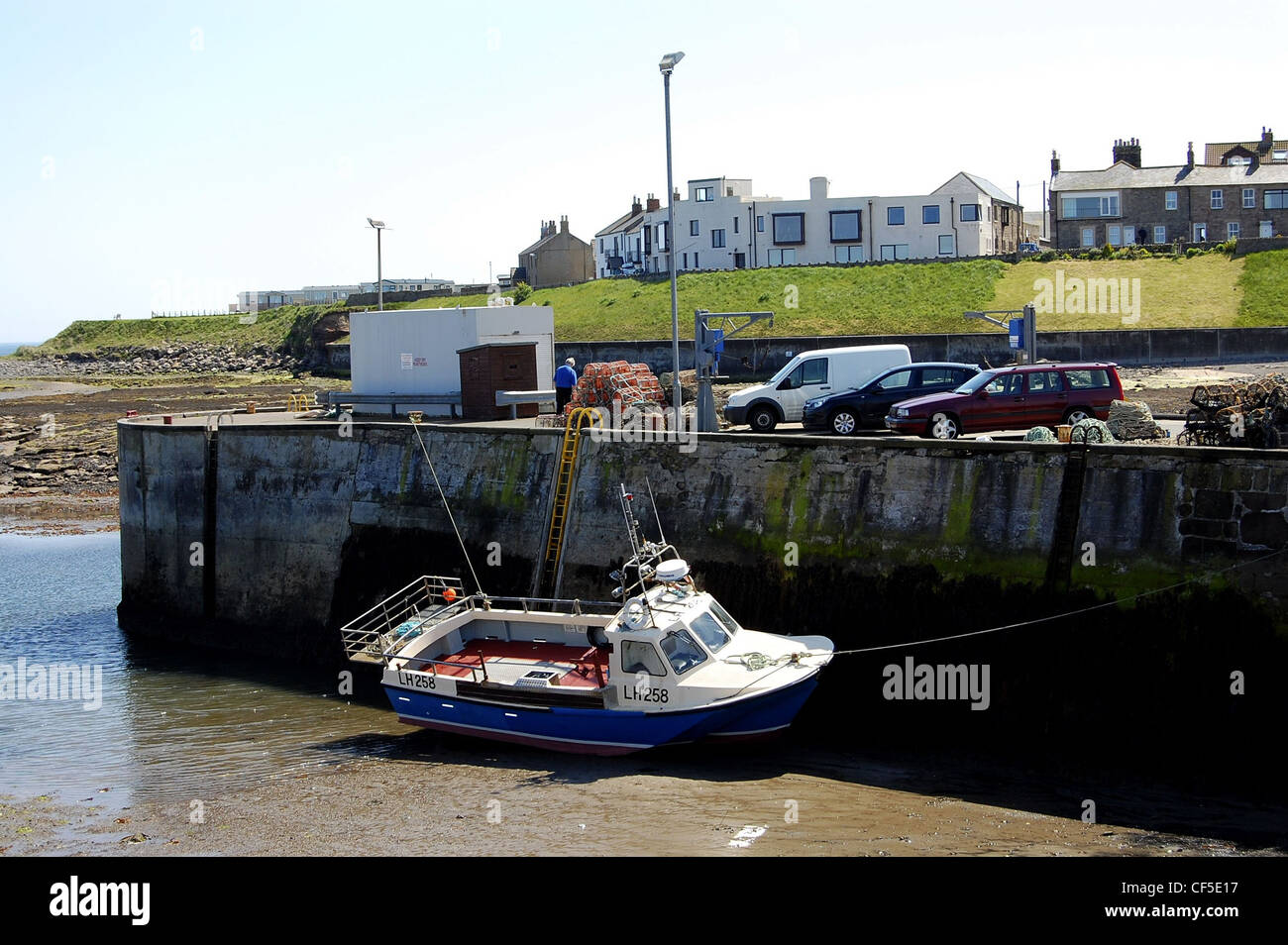 Seahouses harbour with boat resting on the bottom of the harbour at low ...