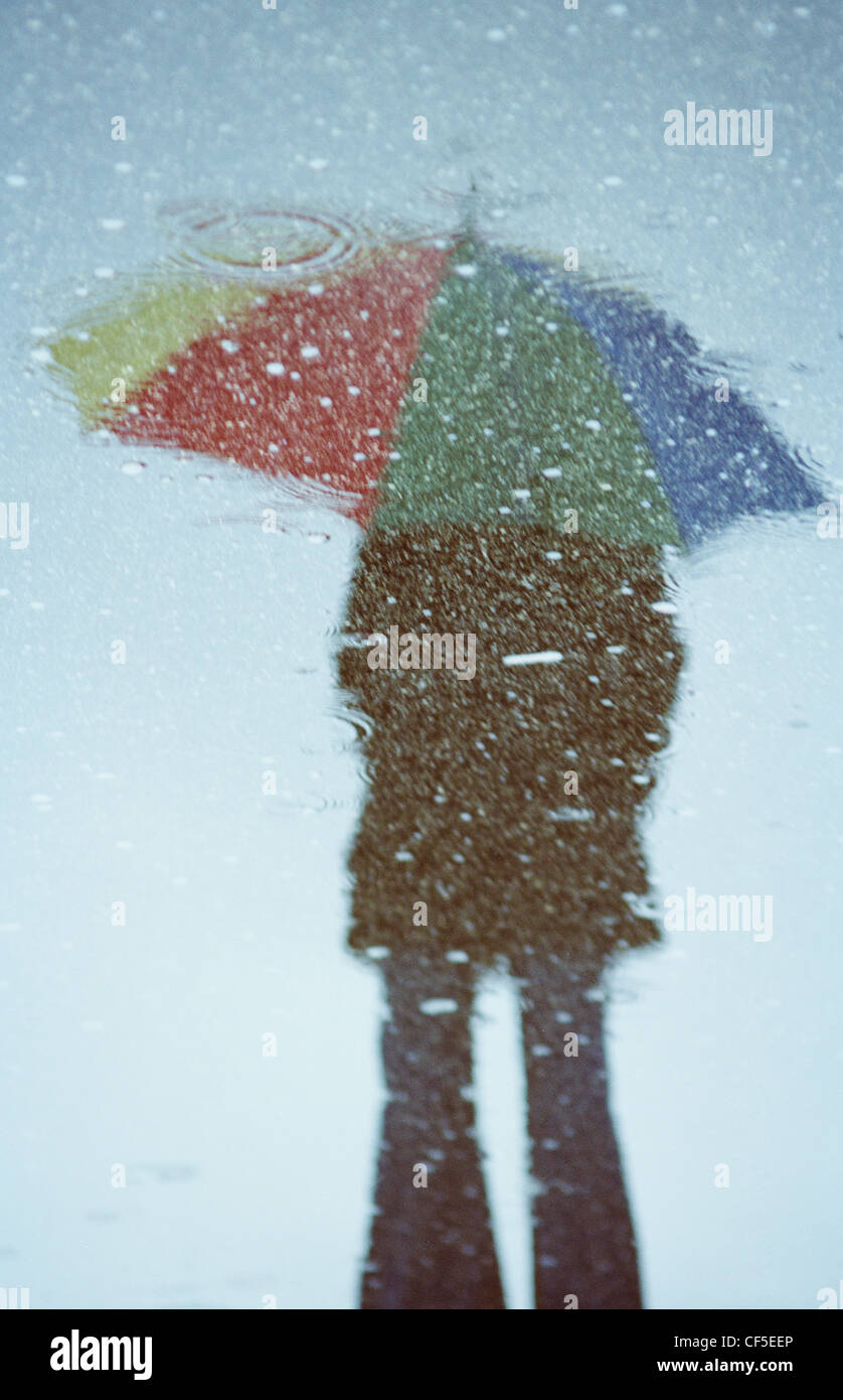 Germany, Bavaria, Huglfing, Young woman with umbrella reflecting in ...