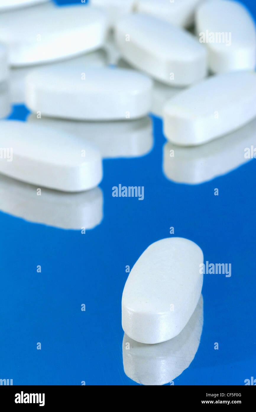 White oblong shaped tablets on a reflective background Stock Photo - Alamy